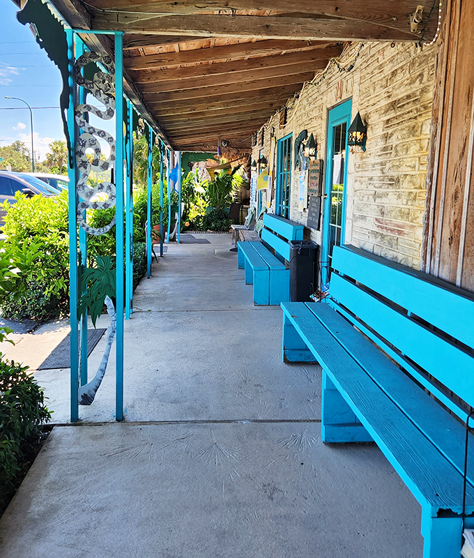 The turquoise benches along this weathered porch aren't just seating&mdash;they're front-row tickets to a slice of Florida that refuses to be paved over.