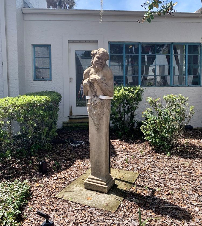 This weathered philosopher stands sentinel in the garden, his stone gaze contemplating eternity amid tropical splendor.