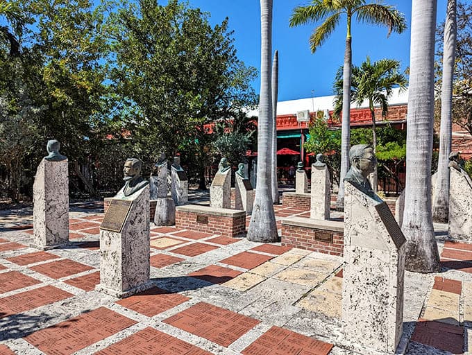 Multiple bronze figures stand among the palms, creating a cocktail party atmosphere where everyone's dressed in their finest patina.