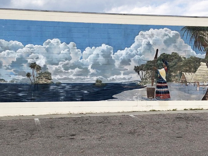 Ancient Florida comes alive in this atmospheric lakeside scene, where indigenous figures stand against a dramatic sky that seems to change with the light.