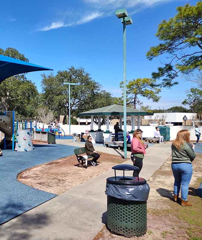 Parents mastering the art of relaxed supervision, also known as sitting down while still technically watching the children play.