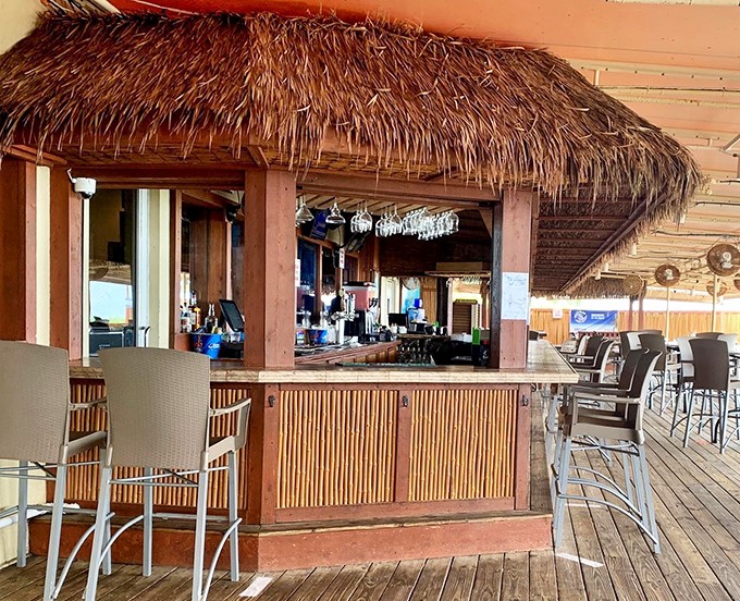 The thatched-roof outdoor bar brings tropical vibes and cold drinks to sun-kissed patrons enjoying the ocean air.