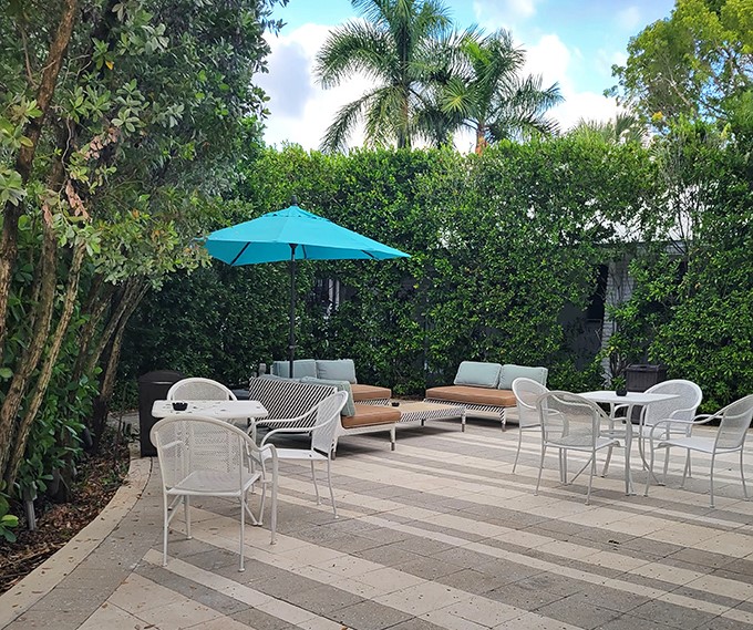 A secret garden hideaway where lush greenery creates natural walls around white furniture &ndash; conversation and cocktails encouraged.