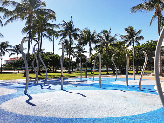 Kids discovering the joy of unexpected water jets, creating a symphony of squeals and giggles under swaying palms.