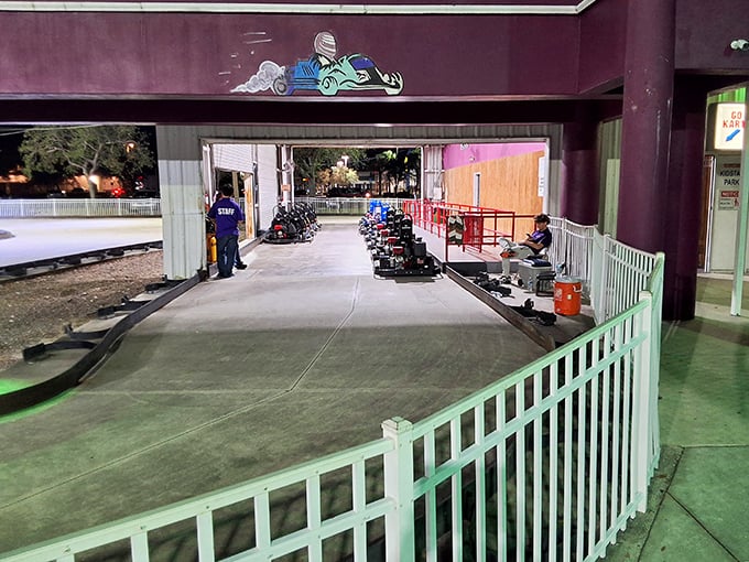 The outdoor go-kart staging area buzzes with anticipation as racers prepare for their turn on the winding track.