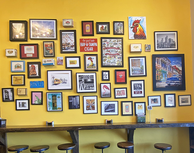 The yellow wall gallery creates a vibrant backdrop for your dining experience, showcasing everything from vintage Cuban posters to local artwork.