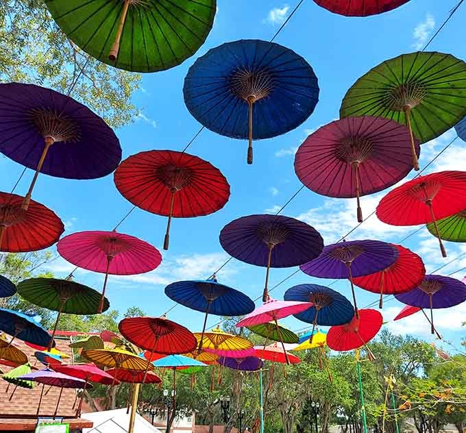 A canopy of colorful umbrellas transforms the outdoor space into an Instagram-worthy wonderland that's pure visual joy.