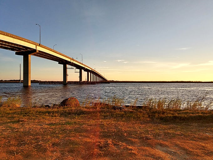 The bridge stretches across Apalachicola Bay, bathed in golden hour light that transforms an ordinary crossing into a magical gateway.