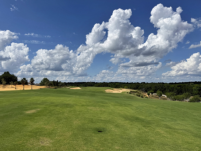 The golf course stretches toward the horizon under Florida's dramatic sky, daring players to focus on their swing rather than the view.