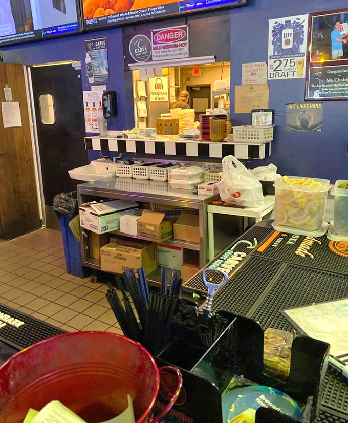 Behind the scenes where wing magic happens. That "Danger: Wings Hot" sign isn't just cute—it's a legitimate public service announcement.