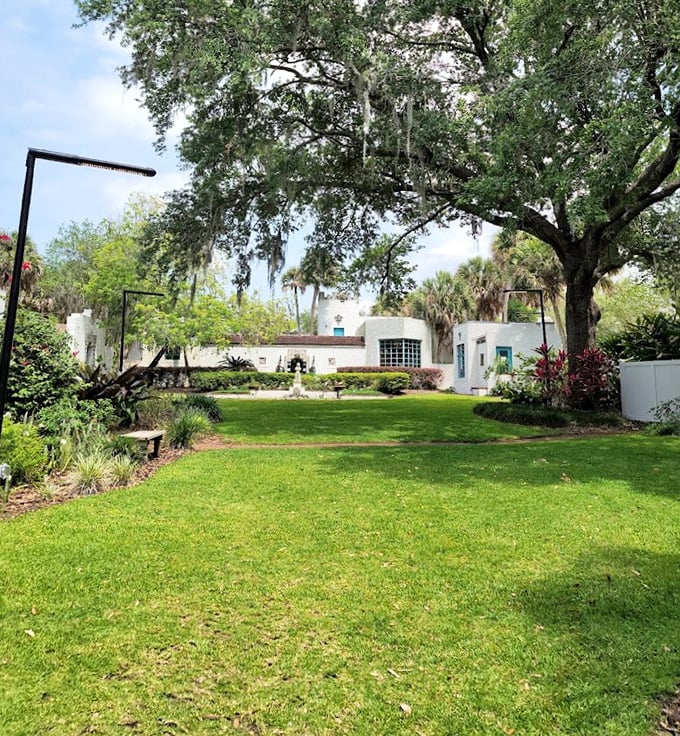 Emerald carpet unfurls beneath towering palms, creating nature's perfect frame for this architectural anomaly in suburban Florida.