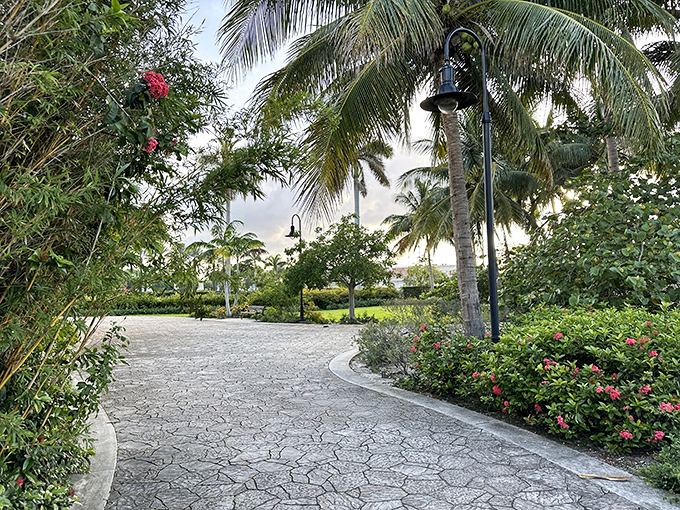 Tropical landscaping creates a lush frame for the pathway leading to the statue – anticipation building with every step.