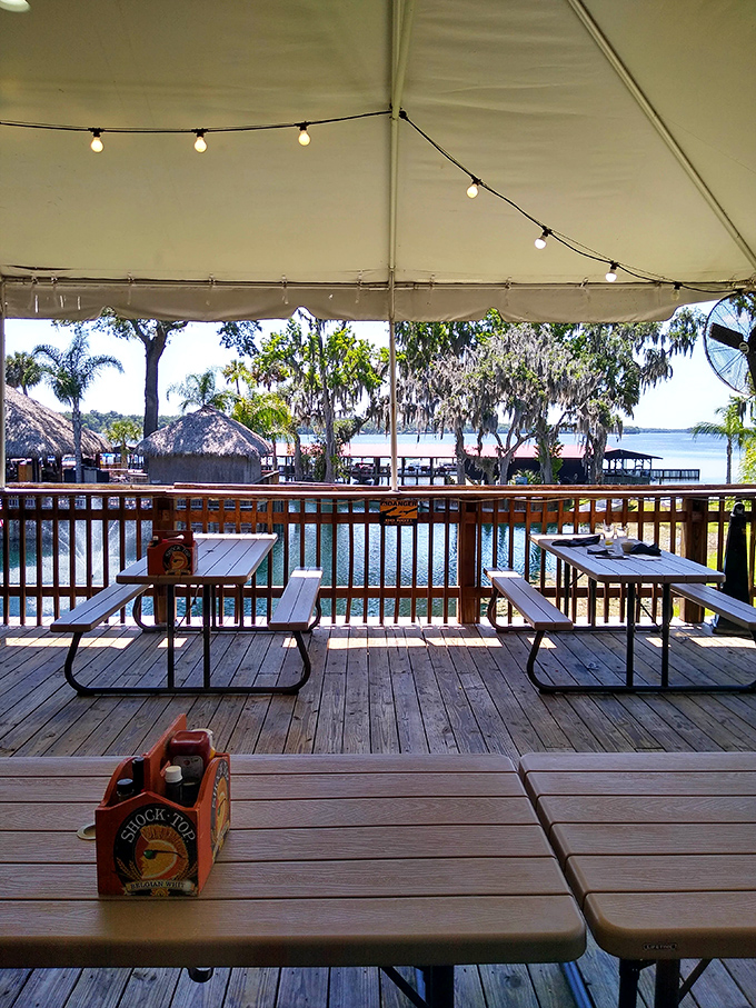 String lights create a magical atmosphere as dusk falls, transforming the outdoor dining area into an enchanted riverside retreat.