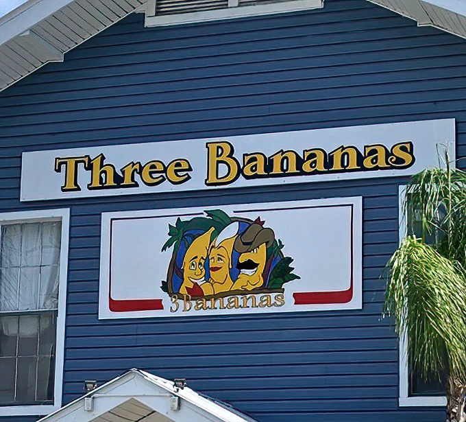 The Three Bananas sign featuring cartoon mascots sets the tone &ndash; serious about food, not so serious about everything else.