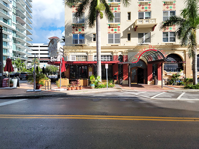 Street-level charm with a splash of red welcomes visitors, while potted plants stand guard like leafy bouncers with excellent taste in architecture.