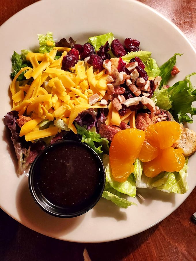The Signature Salad arrives as a colorful arrangement with bacon, mandarin oranges, and hand-shredded cheddar &ndash; a refreshing counterpoint to heartier offerings.