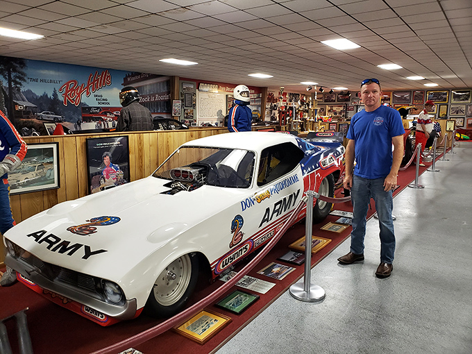 A visitor admires a pristine dragster, perhaps imagining the roar of its engine and the rush of acceleration.