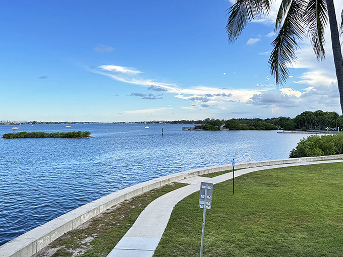 The waterfront promenade offers unobstructed views of Lake Worth Lagoon, with glimpses of Palm Beach visible across the water.