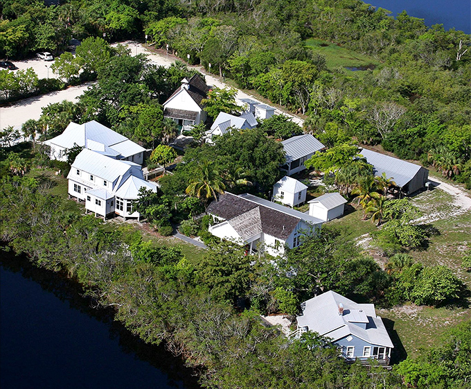 Aerial View: From above, the village reveals itself as a carefully preserved pocket of old Florida, white rooftops gleaming amid lush greenery beside tranquil waters.