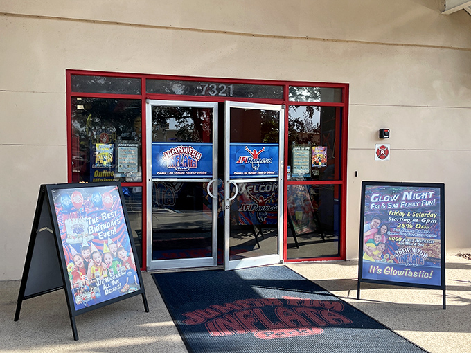 The entrance beckons with promises of inflatable adventures and special events like the glow nights advertised on the sidewalk sign.