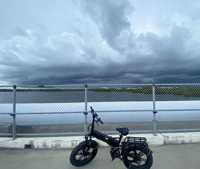Storm clouds gather dramatically over the trail, reminding cyclists that Florida weather keeps things interesting and that checking forecasts is always wise advice.