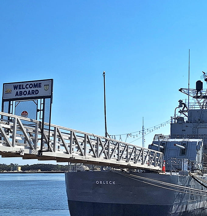 The gangway welcomes visitors aboard with a friendly sign, inviting landlubbers to experience authentic naval history up close.