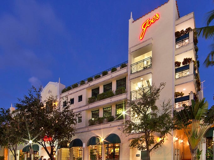 Joe's Stone Crab glows with old-Florida elegance against the Miami Beach night sky, its iconic neon sign beckoning seafood lovers for generations.