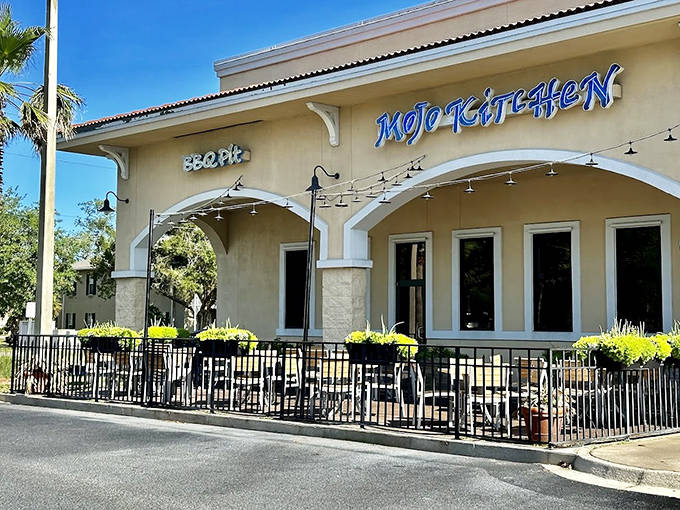 The inviting exterior of MOJO Kitchen features a clean, modern design with "MOJO KITCHEN" proudly displayed, promising BBQ delights inside.