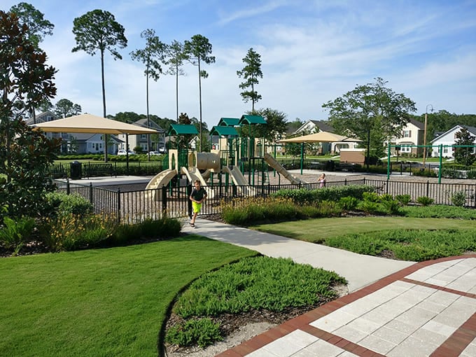 Manicured playgrounds and walking paths show how family-friendly neighborhoods blend recreation with perfectly maintained green spaces throughout.