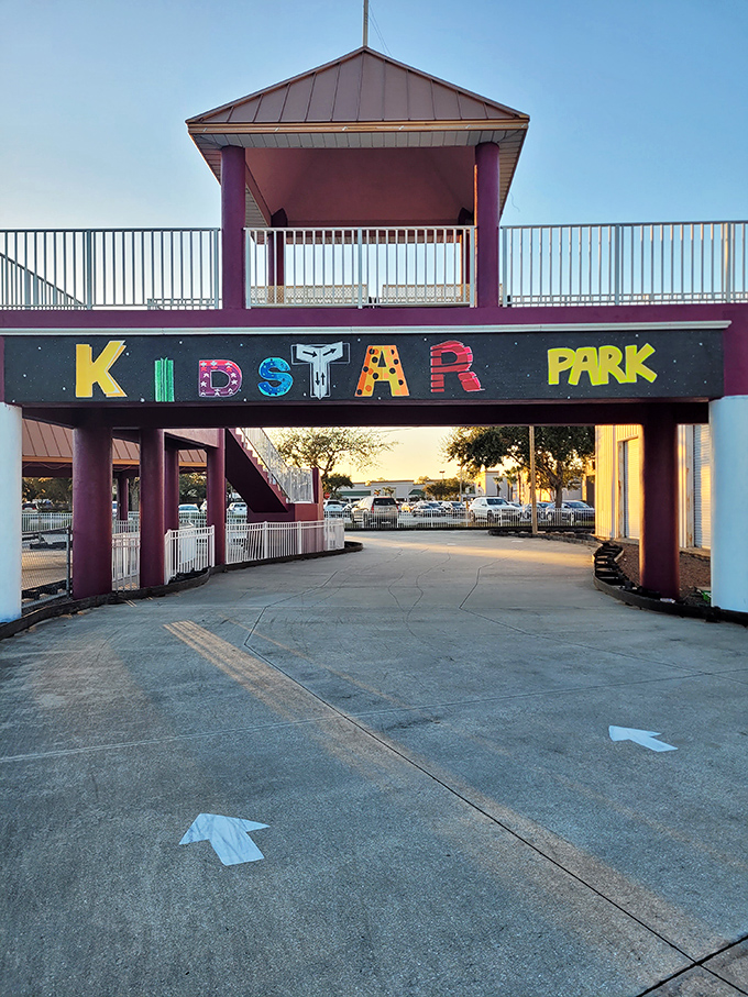 The colorful lettering of KidStar Park's entrance sign practically sings with excitement, each letter a different hue against the night sky.