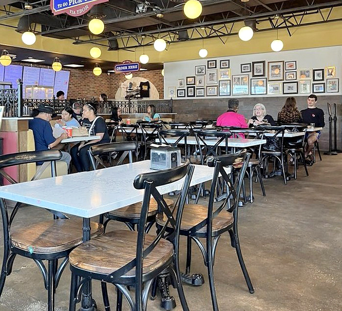 Inside, globe lights cast a warm glow over marble-topped tables where locals gather daily, sharing stories and sandwiches with equal enthusiasm.