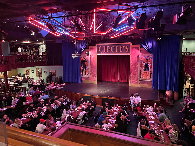 The main theater comes alive with neon lights and anticipation as guests settle in for an evening of gangster-themed entertainment.