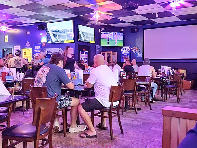 Purple-hued lighting bathes the lively dining area where sports fans gather. It's like your favorite uncle's basement got a serious upgrade.