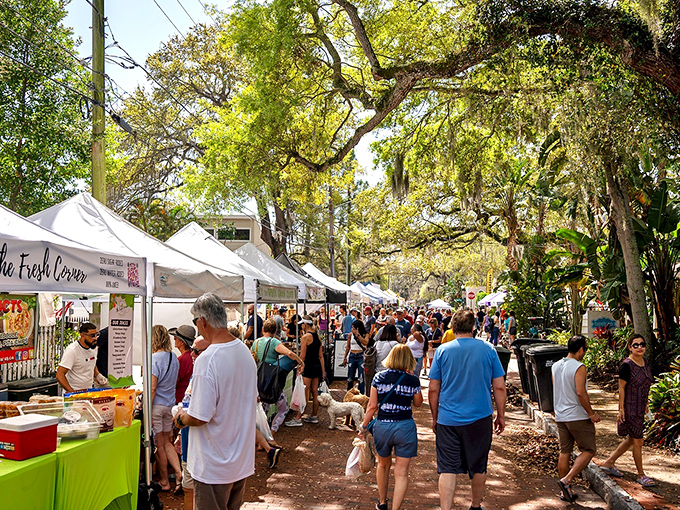 Dappled sunlight filters through ancient oak trees, creating nature's perfect lighting for this bustling marketplace where locals and visitors mingle freely.