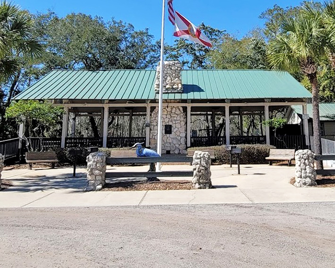 The rustic pavilion stands as a welcoming outpost, its green roof and stone columns blending harmoniously with the surrounding wilderness.