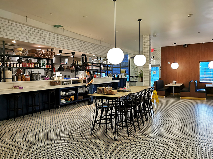 Penny tiles meet pendant lighting in this culinary corner where vintage vibes and modern Mediterranean flavors create a neighborhood gathering spot.