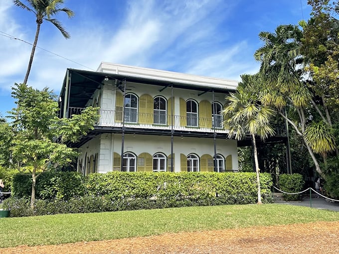 The Spanish Colonial charm of Hemingway's Key West sanctuary stands proudly against a brilliant blue Florida sky.