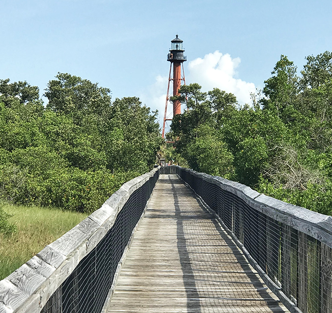 Walkboard to Lighthouse: The wooden pathway stretches toward history, inviting adventurers to leave footprints where lighthouse keepers once tread.