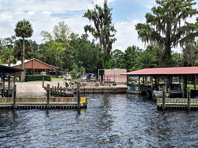 A panoramic view of the resort showcases its perfect integration with nature, where wooden docks extend like fingers into the calm waters.