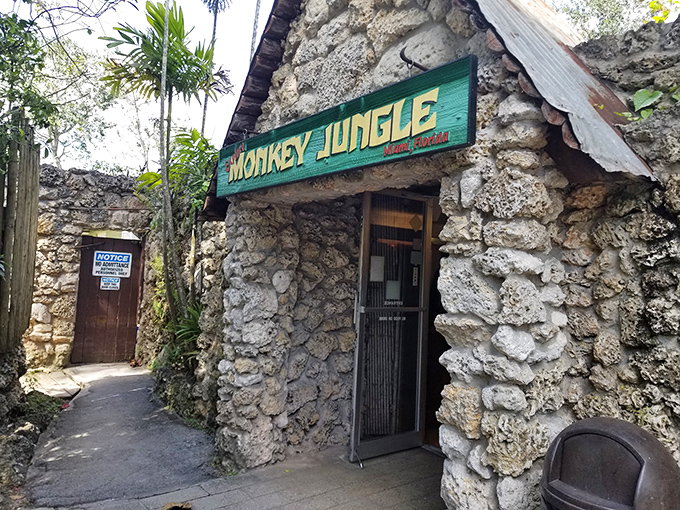 The rustic stone entrance to Monkey Jungle stands as a portal between worlds, promising wild encounters just beyond its weathered facade.