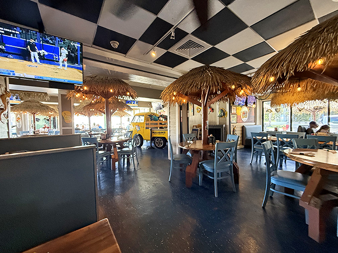Tiki umbrellas indoors? Genius! It's like they've weather-proofed paradise with these palm-thatched dining pods and checkered ceilings.