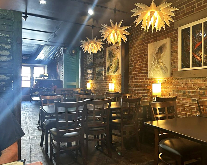 Exposed brick meets artistic lighting in a space that feels like a sophisticated loft crashed into a coastal town and decided to stay.