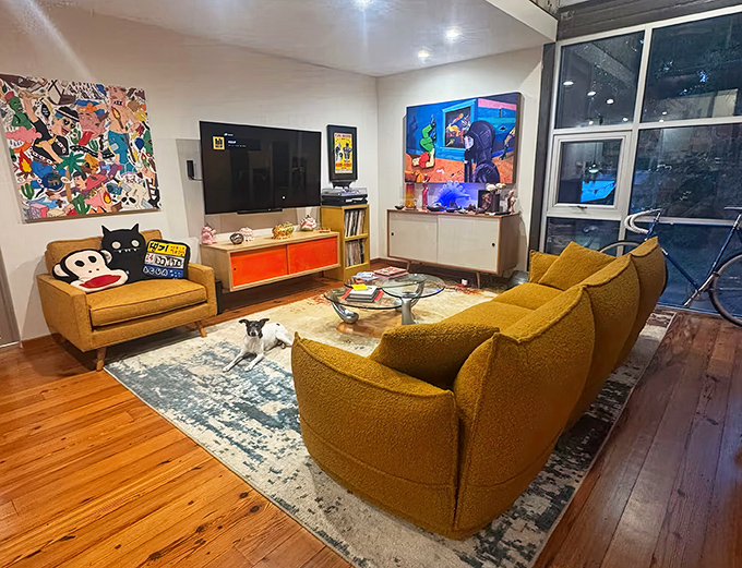 Mid-century modern meets container chic with mustard furniture and eye-popping artwork creating a space that's both Instagram-worthy and nap-approved.