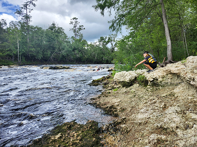 A hiker navigates the rocky shoreline of the Suwannee River at Big Shoals State Park, where Florida's largest rapids can be found.