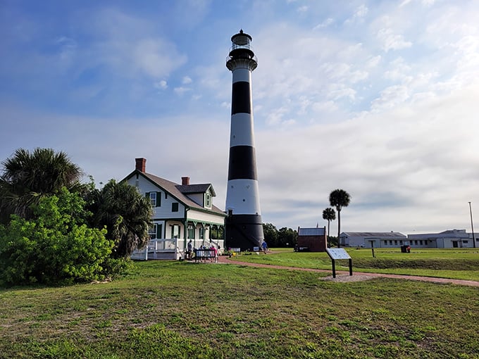 Cape Canaveral Lighthouse's bold black and white stripes create a striking silhouette against the bright Florida sky, standing tall where rockets and ships share the horizon.
