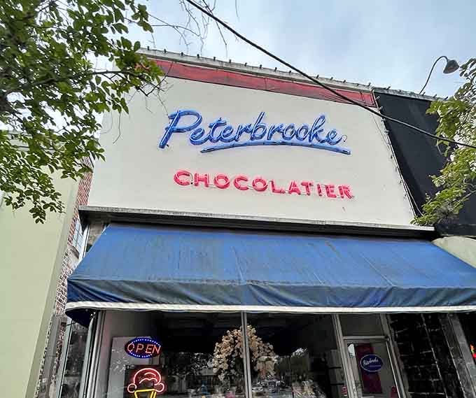 Peterbrooke's vintage neon sign glows with the promise of handcrafted chocolate delights waiting just beyond those doors.
