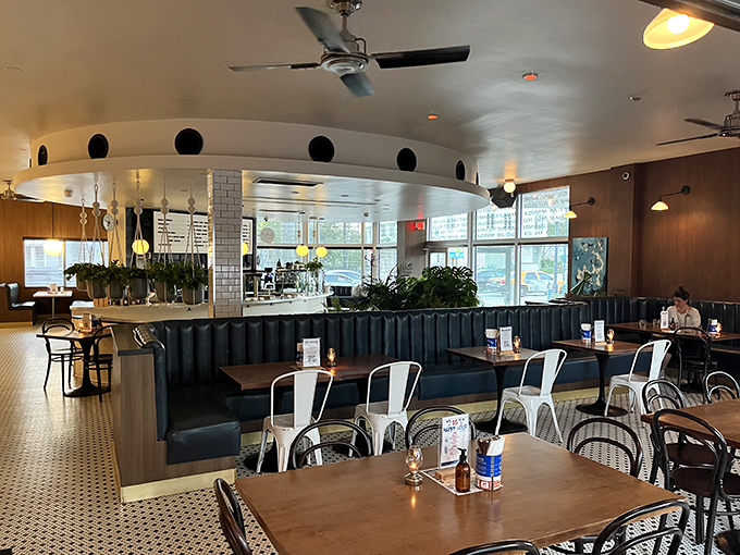 Navy booths and warm wood tones invite lingering conversations in this dining space where mid-century charm meets contemporary comfort.