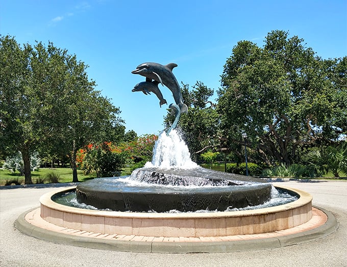 Bronze dolphins leap joyfully from splashing waters, creating both a stunning visual centerpiece and a favorite photo spot.