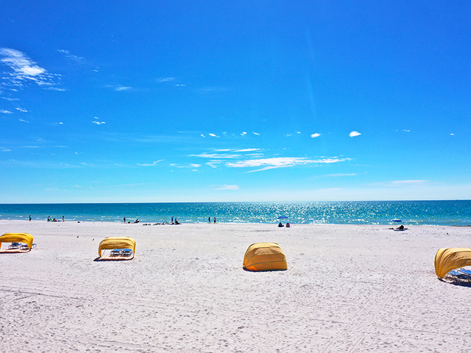 Yellow cabanas dot the pristine shoreline, offering beachgoers their own private oasis amid Treasure Island's expansive sandy paradise.