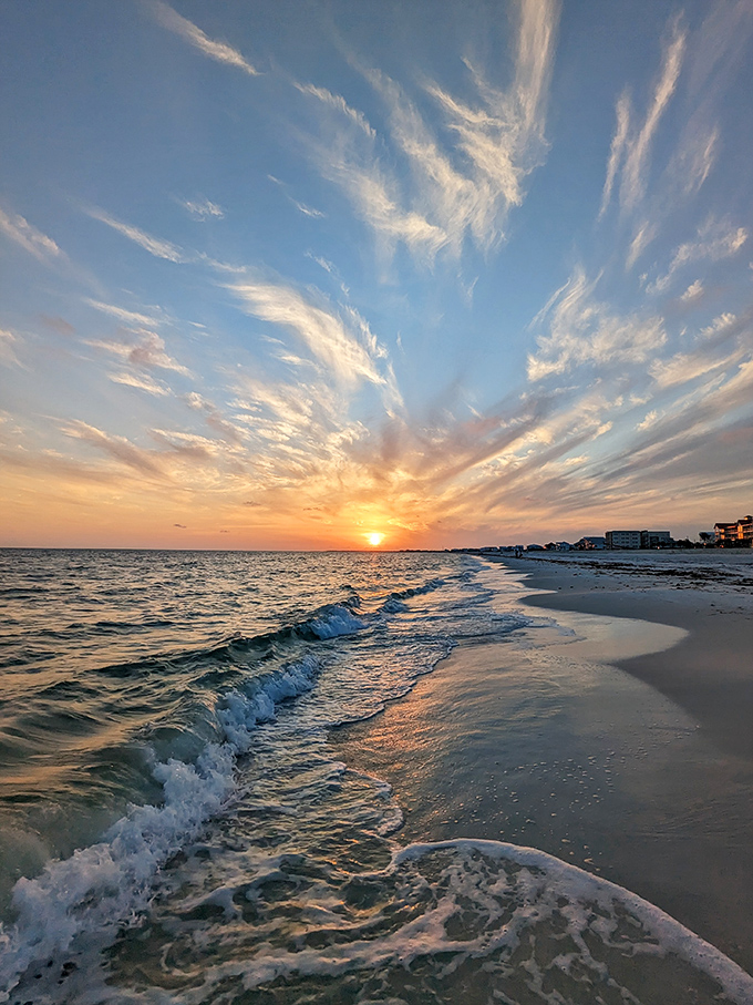 Gentle waves kiss the shoreline, leaving temporary signatures in the sand before retreating back to the Gulf.